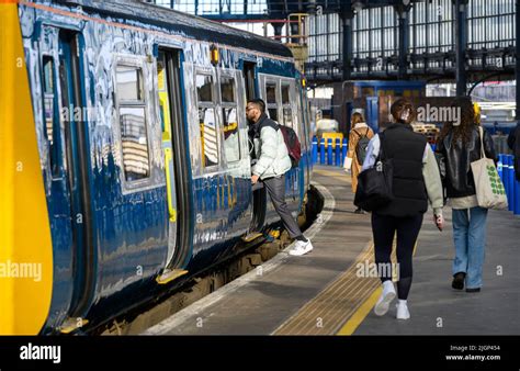 Passengers Boarding A British Rail Class 313 Train In Southern Livery