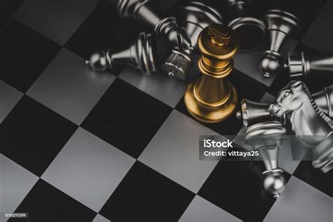 어두운 배경 체스 전투 승리 성공 팀 리더 팀워크 비즈니스 전략 개념과 체스 보드 게임 대회에 실버 체스 조각으로 둘러싸인 황금 왕의 최고보기 샷 결정에 대한 스톡 사진 및