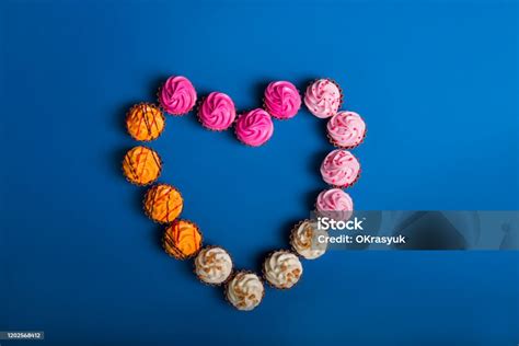 최고보기 클래식 블루 컬러 배경에 하트 모양으로 배열 된 여러 가지 빛깔의 크림 충전 초콜릿 과자 모든 종류의 해피 발렌타인 데이 축제 개념을 사랑 해요 플랫 레이 공간을