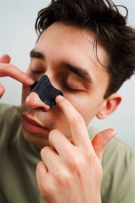 Man With Charcoal Nose Strip For Pores Cleaning Young Guy Applying