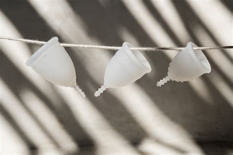 어두운 그림자와 미니멀 한 배경에 실리콘 생리 컵의 다른 크기 재사용 가능한 친환경 여성 위생 제품 제로 폐기물 지속 가능한