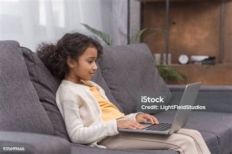 집에서 소파에 노트북을 사용 하 여 아프리카계 미국인 아이의 측면 보기 소녀에 대한 스톡 사진 및 기타 이미지 소녀 아프리카계 미국 민족 우크라이나 Istock