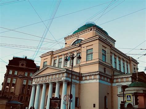 an old building with columns and a clock on the top is surrounded by ...