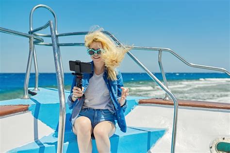 젊은 여자 는 바다에서 요트의 보드에 앉아 스마트 폰에 스트림을 기록 계절에 대한 스톡 사진 및 기타 이미지 계절 관광 관광객 Istock