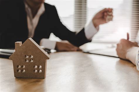 부동산 브로커 관리자 주는 키 하우스 모델 투자 주택 융자 계약에 뒤에 부동산 에이전트 사무실에서 집 구입을 위한 계약에 서명 후 고객 구입 하 고 판매 하는 하우스 개념