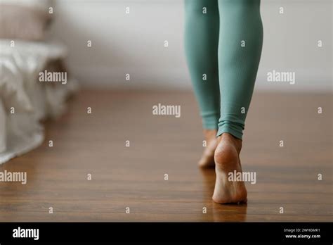 Young Woman In Sports Leggings Walks Barefoot On The Warm Floor In The