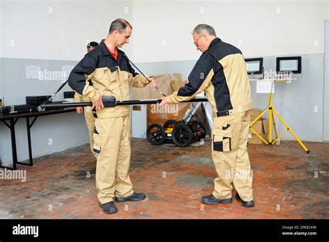 Radiation Detector Testing Two Dosimetrists Adjusting A Portable Gamma Radiation Dosimeter Set