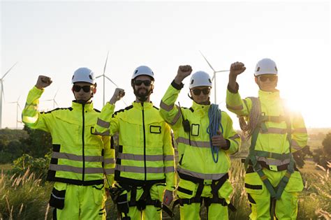 남성 엔지니어 그룹이 서서 풍력 터빈 농장에서 함께 손을 들고 안전 유니폼과 헬멧을 착용하고 있습니다 팀 엔지니어 작업이 완료되었습니다 성공적인 작업 20 24세에 대한