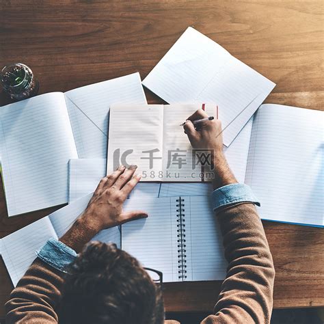 思考、计划和集思广益的商人在桌子上从上面阅读和写笔记。高清摄影大图 千库网