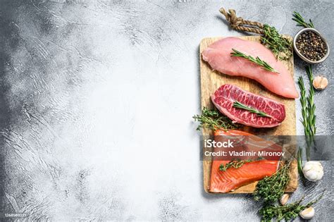 허브와 도마에 원시 고기의 다른 유형 쇠고기 상단 블레이드 연어 필렛과 터키 유방 스테이크 흰색 배경입니다 맨 위 보기입니다 복사 공간 0명에 대한 스톡 사진 및 기타