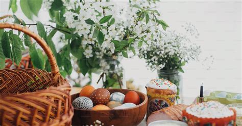 부활절 달걀 천연 염색 부활절 빵 햄 사탕무 버터 녹색 가지 고리 버들 바구니와 촛불이 있는 소박한 나무 테이블에 꽃 교회에서 축복을위한 전통 부활절 음식 사진