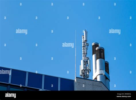 Telecommunication Antennas And Chimneys On The Roof Of A Building