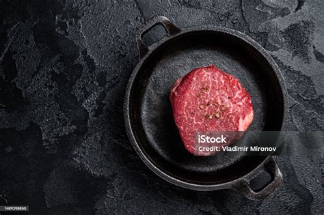 필레 미뇽 프라임 비프 스테이크 요리에 바로 사용할 수 있는 허브와 향신료를 곁들인 생 건조 숙성 대리석 고기 검정 배경입니다
