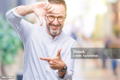 중간 나이 노인의 수석 사람 손으로 만드는 프레임 및 행복 한 얼굴로 손가락을 웃 고 고립 된 배경 위에 안경을 쓰고 창의력과 사진 개념입니다 개념에 대한 스톡 사진 및