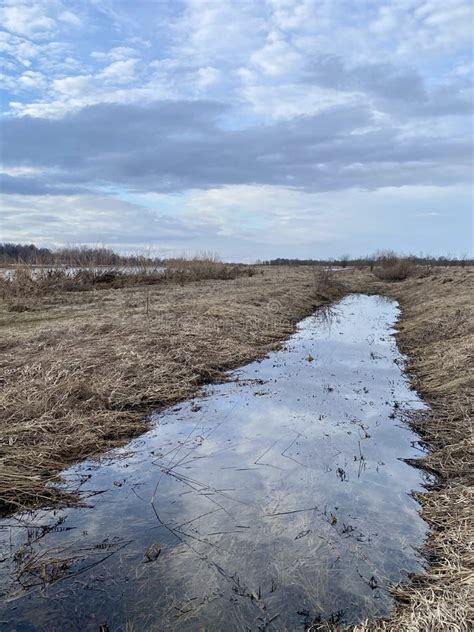 Spring Village Landscape The Sky In The Clouds Dry Grass On The Field A Blue River And A