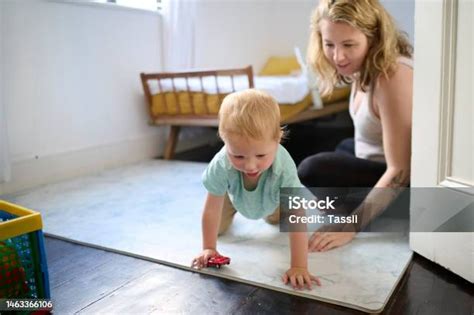 집에서 침실에서 엄마와 함께 유아의 아기 가정 및 이동성 개발 교육 학습 및 어린이 자동차 장난감으로 바닥에 어머니의 사랑과