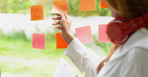 빈티지 톤으로 사무실의 유리 벽에 접착 노트를 붙이는 여자 사진 Unsplash의 그것의 게시 이미지