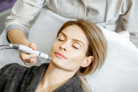 고급 미용실에서 여성에게 뺨 부위에 진공 하이드로 필링을 만드는 미용사 전문적인 얼굴 치료의 개념 사진 Unsplash의 여성 이미지