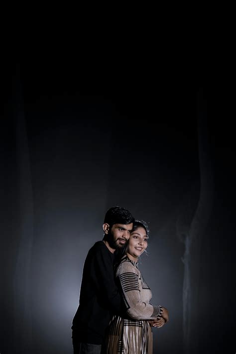 일몰 무렵 모래사장에 앉아 있는 로맨틱한 커플 · 무료 스톡 사진