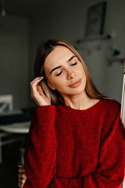 Tendre Fille élégante Avec Un Maquillage Nude Vêtu D un Pull Rouge Les Yeux Fermés Et Souriant