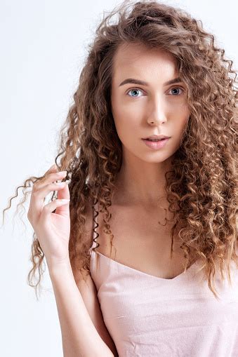 아름다운 곱슬 머리입니다 건강한 물결 모양의 긴 금발 머리를 가진 미소 소녀 뷰티 얼굴 섹시한 메이크업과 완벽한 헤어 컬초상화 행복한 여자 볼륨 헤어 스타일 미용 개념