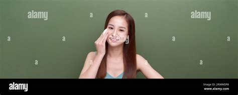 Girl Applying Lotion Using Cotton Pad Over Green Background Panorama
