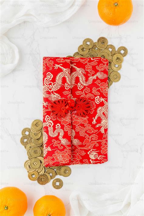 오렌지 옆에 용 디자인이 새겨진 빨간 종이 사진 Unsplash의 중국 설날 행운의 동전 이미지