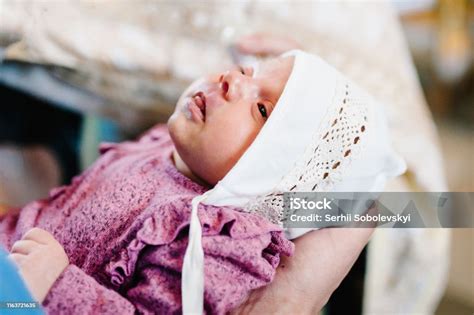 세례 가운을 입고 아기를 가진 교회의 젊은 부모 부모와 대부모는 교회에서 아기와 함께 침례 탕에 서 있다 2명에 대한 스톡 사진 및 기타 이미지 Istock