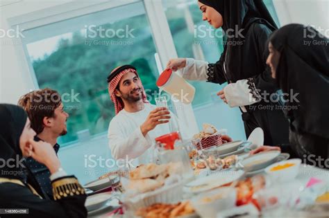 잔치를 깨기 위해 이프타르 저녁 식사를 하는 무슬림 가족 라마단 축제 기간 동안 집에서 전통 음식을 먹습니다 현대 가정에서의 이슬람 할랄 먹고 마시기 Ramadan