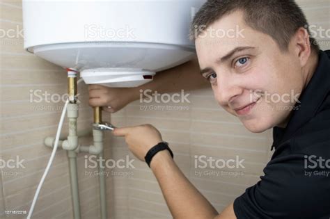 보일러 수리 기술자는 조절 가능한 렌치를 사용하여 파이프의 너트를 풀거나 조입니다 나중에 수리하기 위해 온수기를 설치하거나 손상된 보일러를 분해합니다 공기조화에 대한 스톡