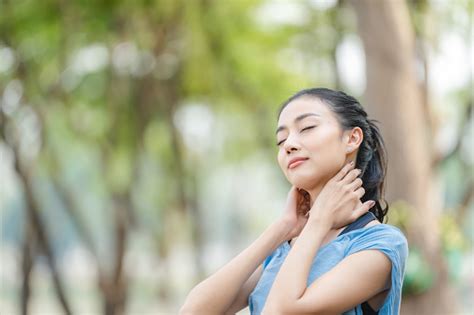 도시의 공원에서 조깅 운동을 한 후 몸과 목을 스트레칭하는 아시아 여성 운동복을 입은 매력적인 운동 선수 소녀는 아침 여름에 야외 라이프 스타일 스포츠 훈련 피트니스 달리기