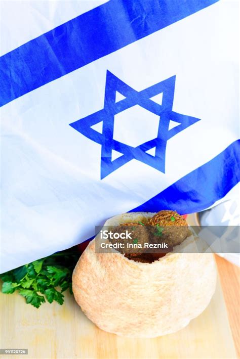 이스라엘 국기 배경 위에 나무 테이블에 피타에 팔라펠 공 빵 먹으면 이스라엘 요리에 상징적인 역할 하 고 국가의 국가 접시 널리 간주 됩니다 0명에 대한 스톡 사진 및 기타