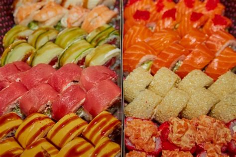 필라델피아 초밥은 검은 포장 상자에 담겨 따뜻한 빛 흐릿한 곳에 클로즈업되어 있습니다 부드럽고 따뜻한 빛의 초밥 재료의 질감과