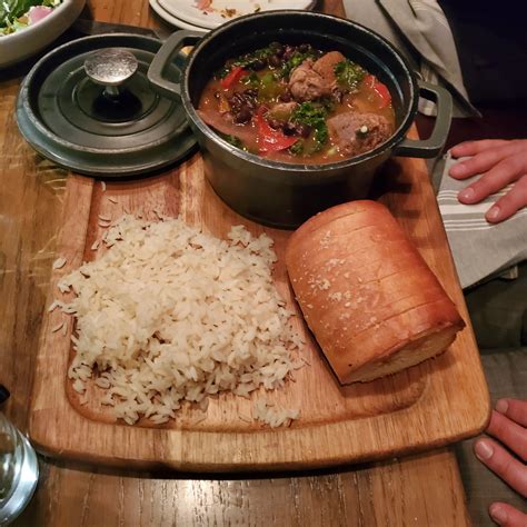 Brazilian Stew Feijoada In A Mini Dutch Oven Served With Rice And Bread On A Chopping Board R