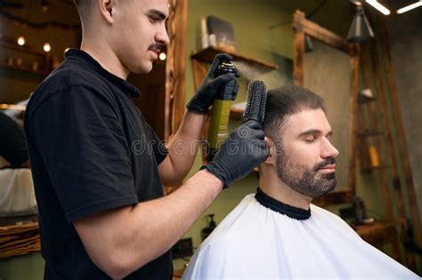 Barber Doing Styling Hair For Man Customer At Barbershop Stock Photo