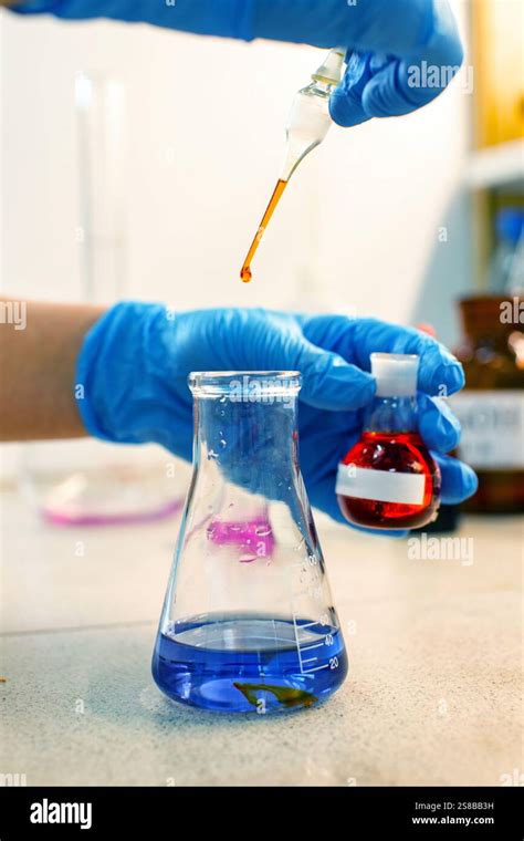 Chemistry Experiment Involves Mixing Colored Liquids In Laboratory Setting With Precise Droplet