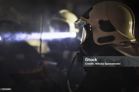 전체 장비 산소 마스크 및 비상 구조 도구 원형 유압 및 가스 톱 도끼 및 썰매 망치를 착용한 전문 소방관 그룹 백그라운드에서 연기와 소방차 2명에 대한 스톡 사진 및 기타