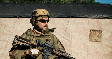 위장복과 헬멧을 쓴 자신감 넘치는 수염 난 군인이 소총을 들고 거리를 바라보고 있다 사진 Unsplash의 특수 부대 이미지