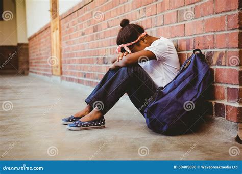 Sad Girl Sitting Against Wall