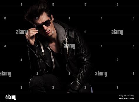 Young Fashion Model In Leather Jacket Taking Off His Sunglasses On
