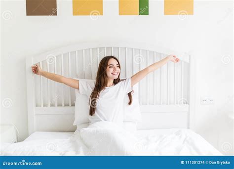 Pretty Happy Girl Waking Up In The Morning And Stretching In Her Bed