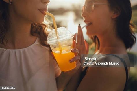 닫습니다 두 예쁜 여자 친구는 일몰 긍정적 인 얼굴 표정 야외에서 빨대와 오렌지 주스를 마십니다 명랑한에 대한 스톡 사진 및 기타 이미지 Istock