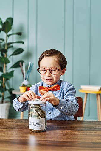 그의 미래를위해 돼지 저금통으로 유리 항아리에 귀여운 아이 저축 돈 2 3 살에 대한 스톡 사진 및 기타 이미지 2 3 살 가계 개념 Istock