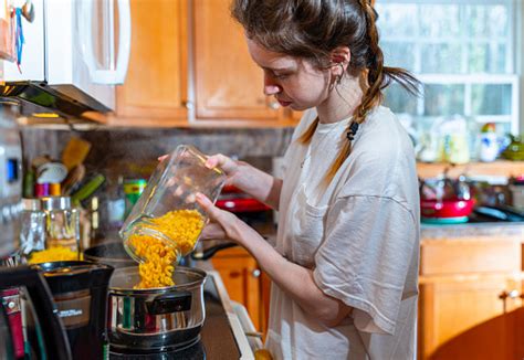 그녀의 가정 부엌에서 저녁 식사를 준비하는 십대 소녀 난로에 끓는 물 냄비에 파스타를 던지고 파스타에 대한 스톡 사진 및 기타 이미지 Istock