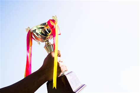 들고 푸른 하늘 빛나는 배경 텍스트 복사 공간 경쟁에서 최고의 성공 성취와 승리자로 서 비즈니스의 상금에 대 한 리본 표시