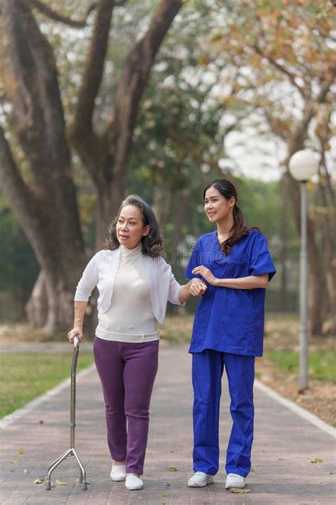 Healthcare Nurse Physical Therapy With Elderly Woman At Outdoor Nurse Holding Hand And Help