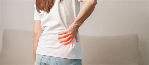 집에서 소파에 앉아 있는 동안 허리가 아픈 여자 이상근 증후군 요통 및 척추 압박으로 인한 근육통이 있는 성인 여성 사무실 증후군과 의료 개념 근육에 대한 스톡 사진 및