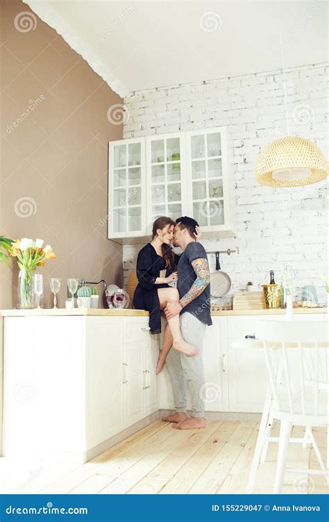 Пара в любов имеет завтрак в кухне рано утром Объятия и поцелуи сексуальная девушка в купальном