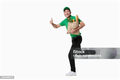 녹색 유니폼을 입은 아시아 배달 남자는 흰색 배경에 고립 된 신선한 음식 종이 가방을 들고 가방에 대한 스톡 사진 및 기타 이미지 Istock