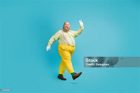 그의 전체 길이 몸 크기보기 그의 좋은 재미 펑키 기쁜 쾌활한 쾌활한 남자 산책 재미 보여주는 V기호 고립 위에 밝은 생생한 빛나는 활기찬 푸른 색 배경 멜빵에 대한 스톡